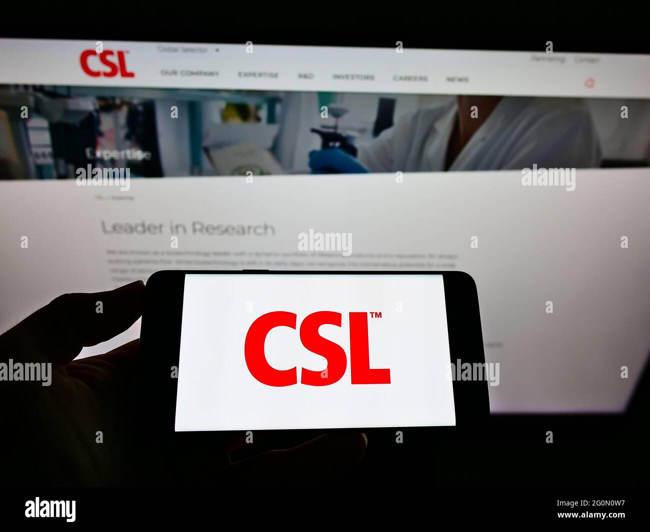 Person holding mobile phone with logo of Australian pharmaceuticals ...