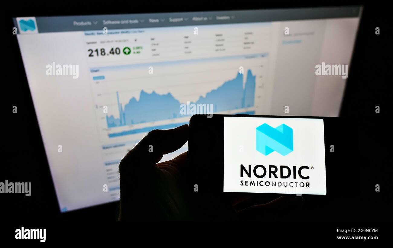Person holding smartphone with logo of Norwegian company Nordic ...