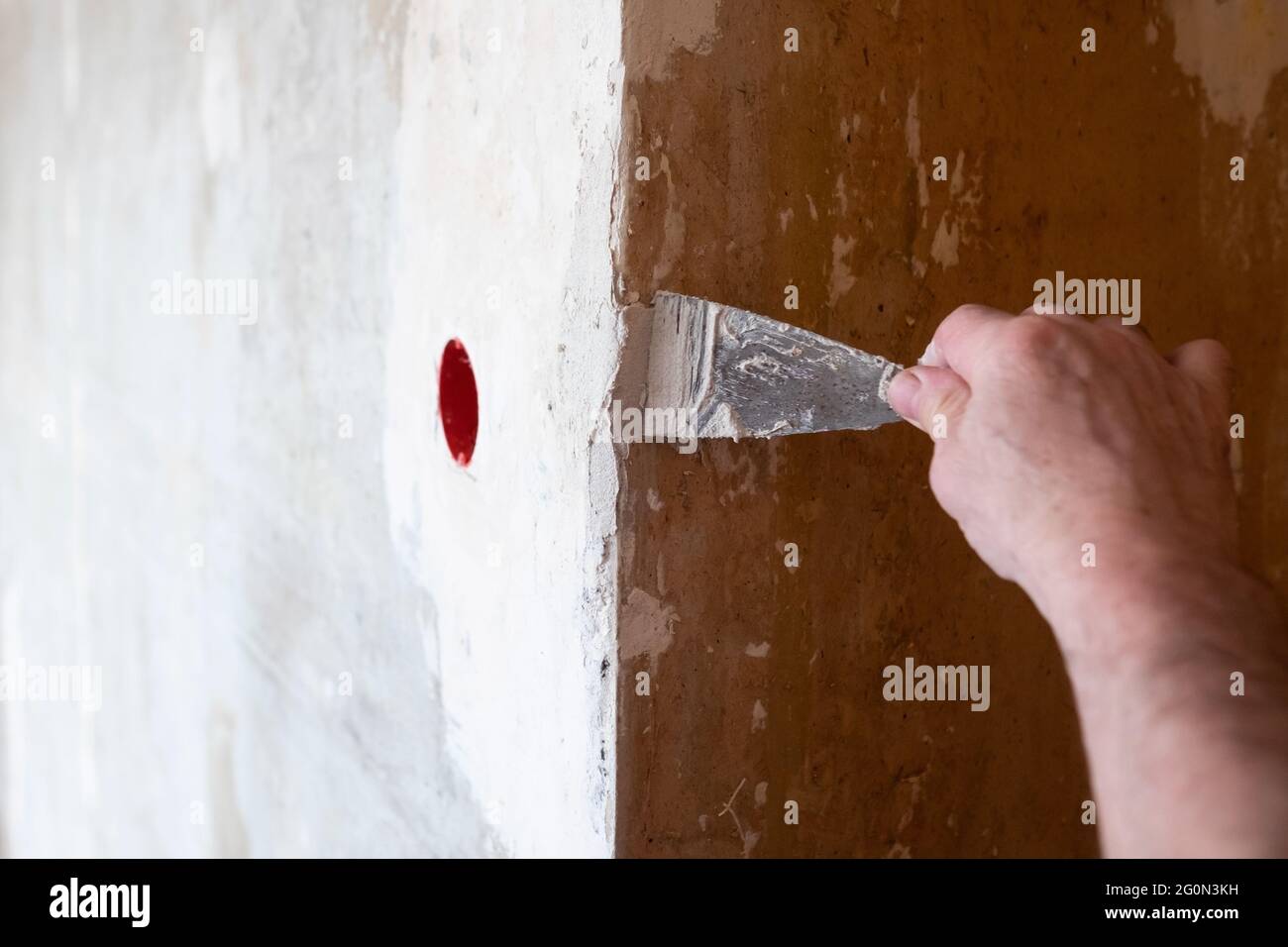 Repairing the wall - Man putting spackle on a hole in the wall Stock ...