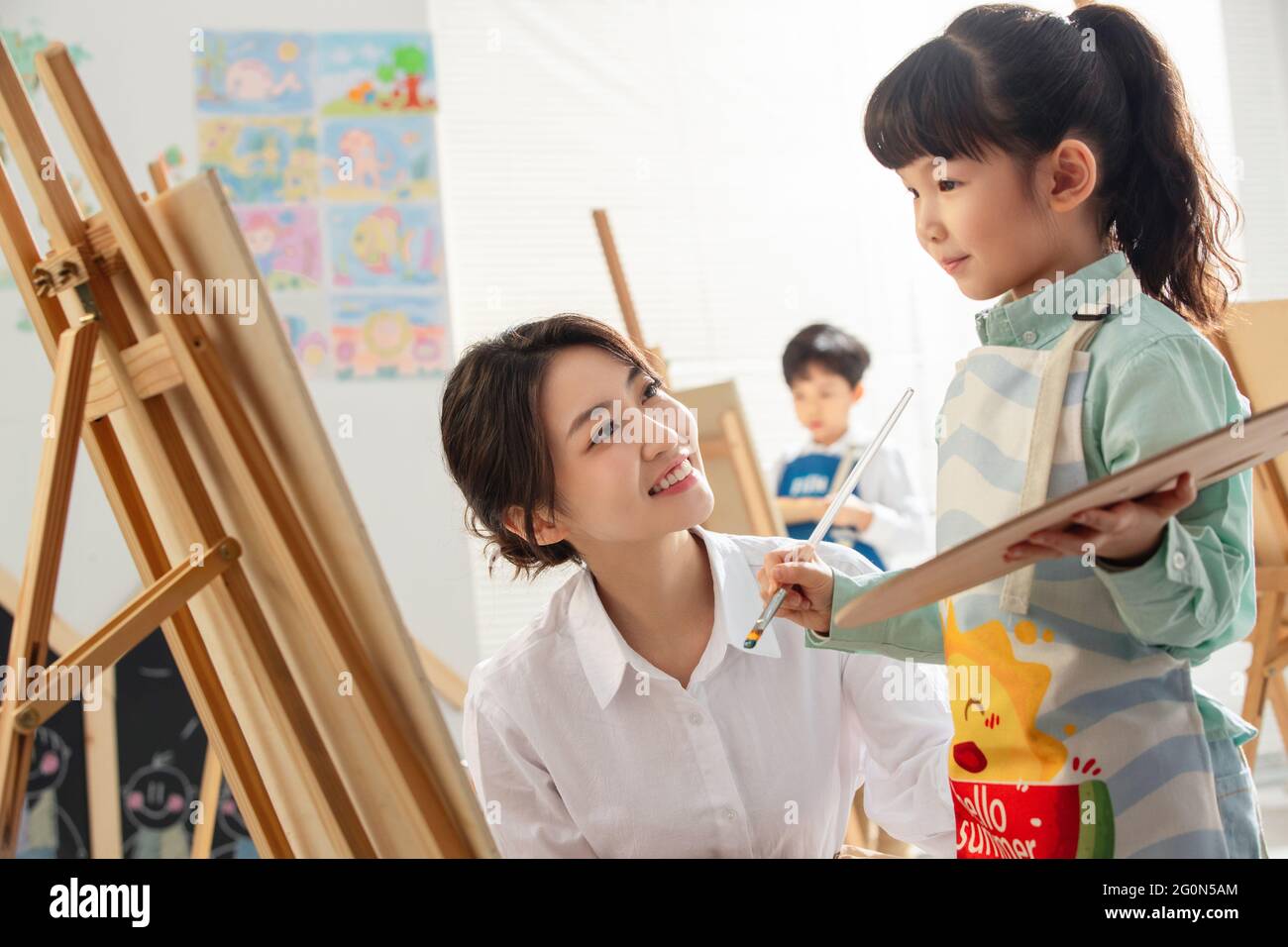 Young women to teach children to draw Stock Photo - Alamy