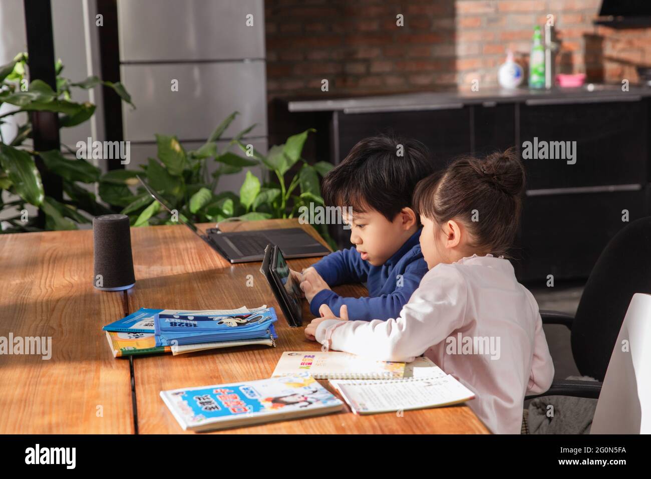 Two children watch mobile phone at home Stock Photo - Alamy