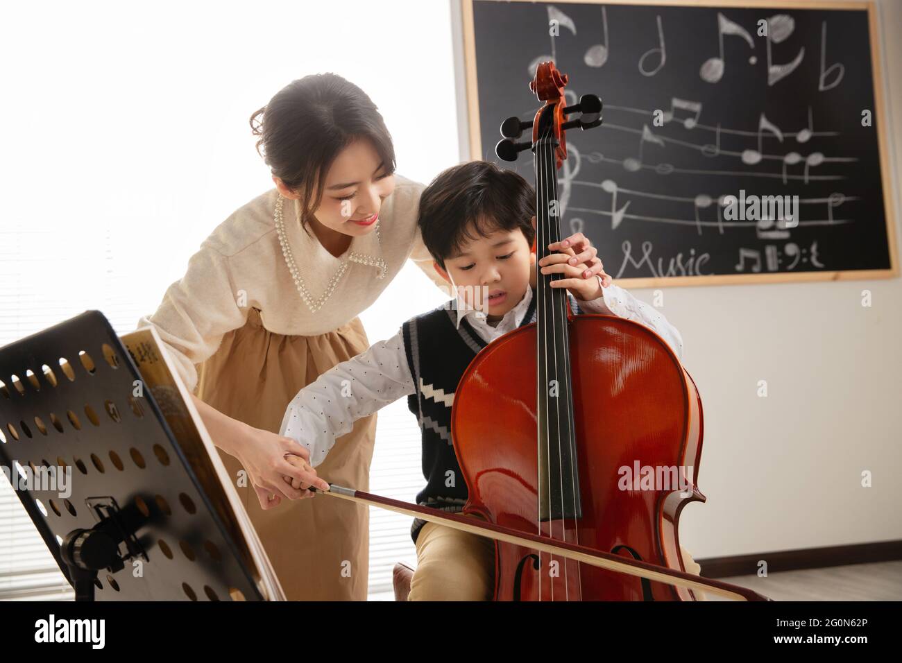 The young woman to guide students learning the cello Stock Photo - Alamy