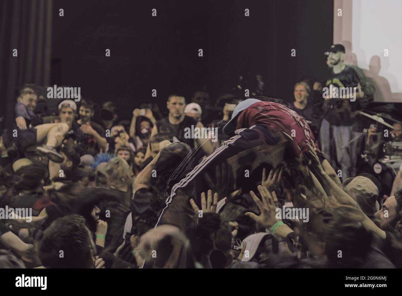 Crowd of concertgoers at a hardcore punk music festival, stage diving ...