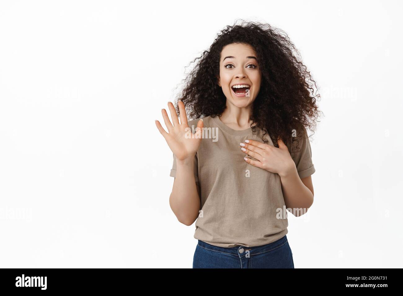 Hello its me. Happy young woman raising hand and name herself, holding ...