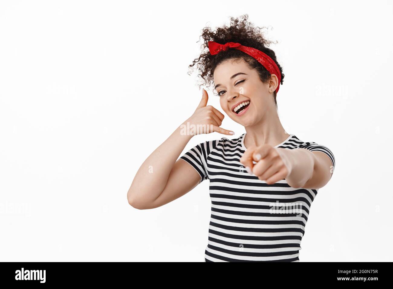 Call me. Smiling young brunette woman showing phone gesture and ...