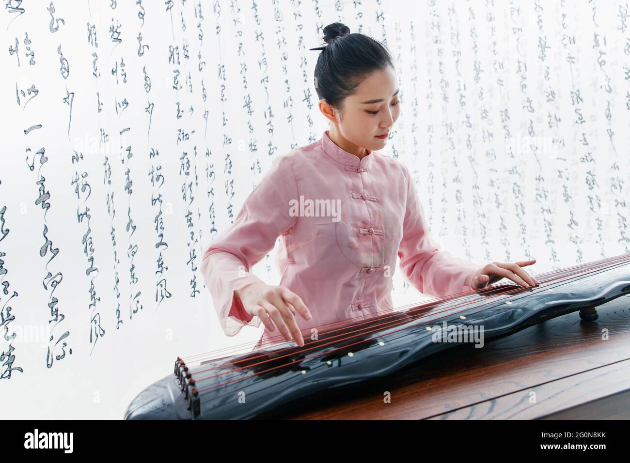 The young woman playing the guzheng Stock Photo - Alamy
