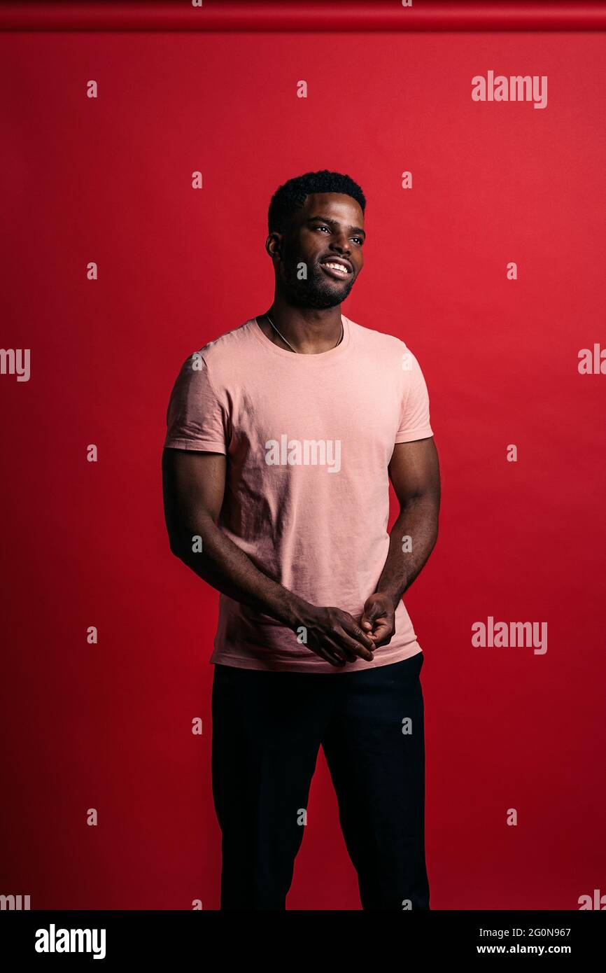 Portrait of young african man on bright red background Stock Photo - Alamy