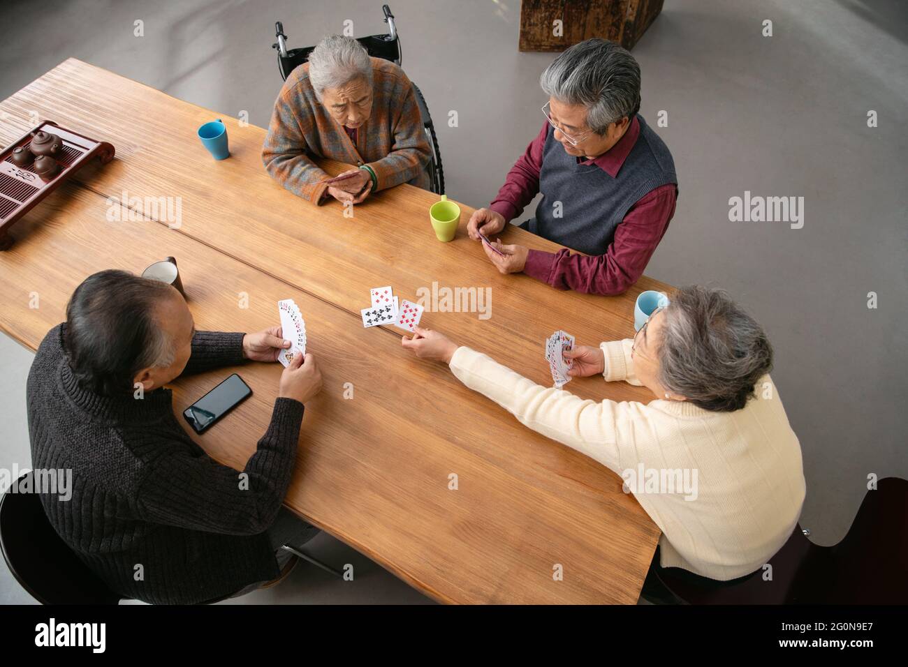 Four elderly friends playing cards hi-res stock photography and images ...