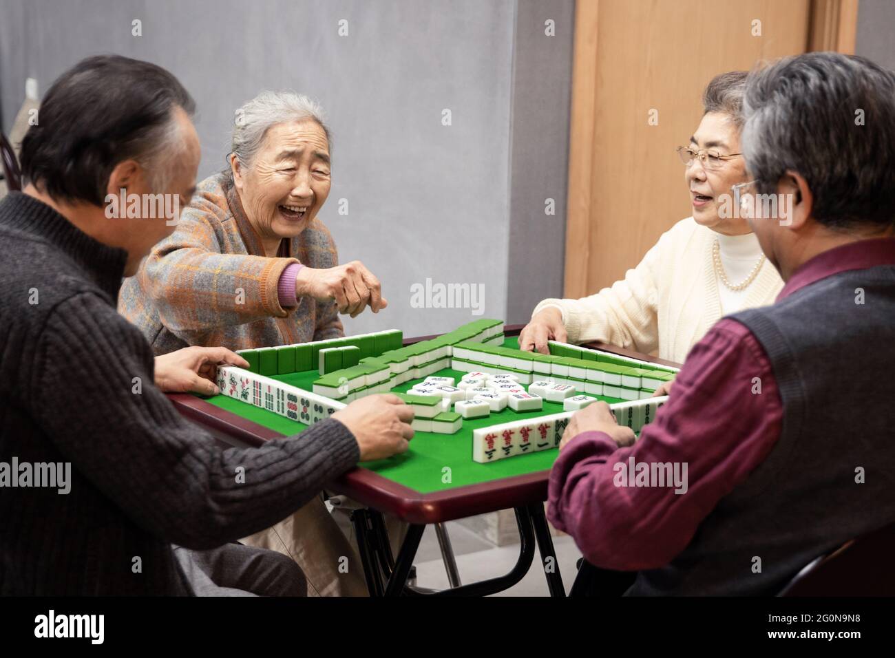 Happy old people playing mahjong Stock Photo - Alamy