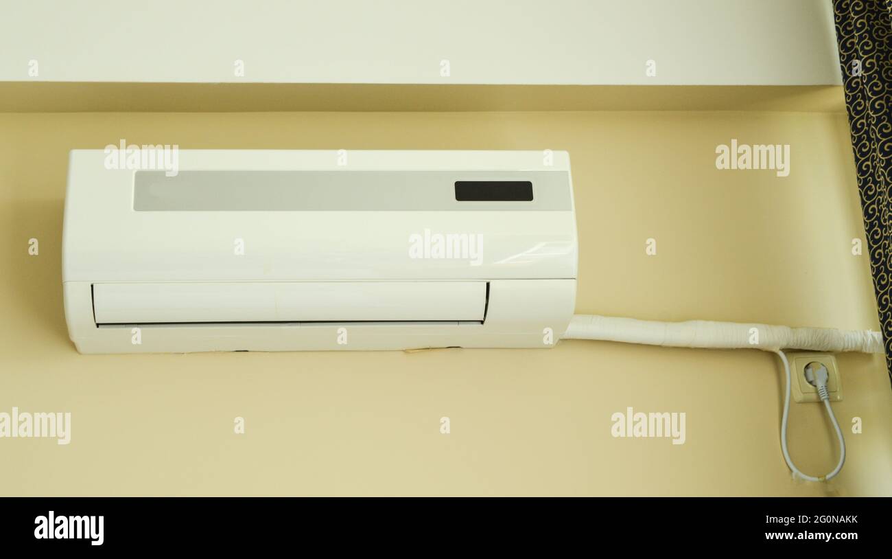 Air conditioning on the yellow wall in the living room Stock Photo - Alamy