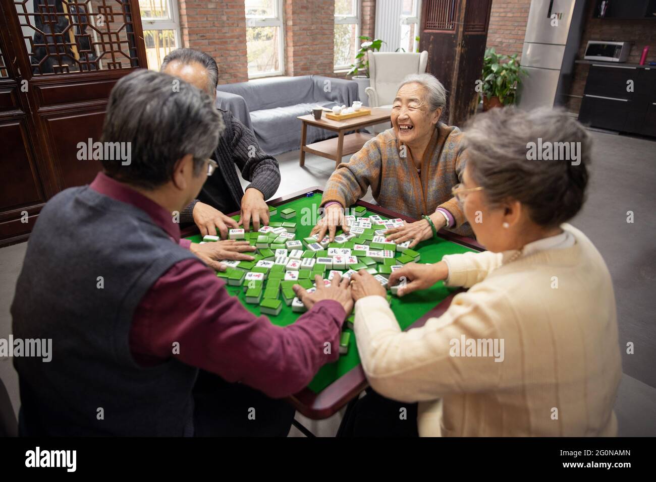 Happy old people playing mahjong Stock Photo - Alamy