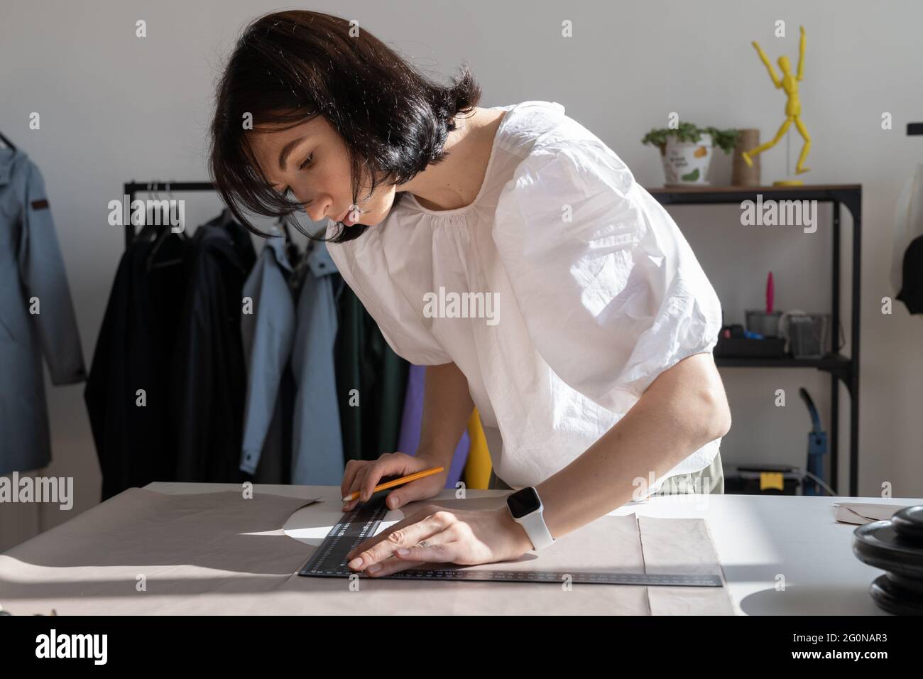 Tailoring process in atelier: dressmaker measure cloth to sew clothes ...