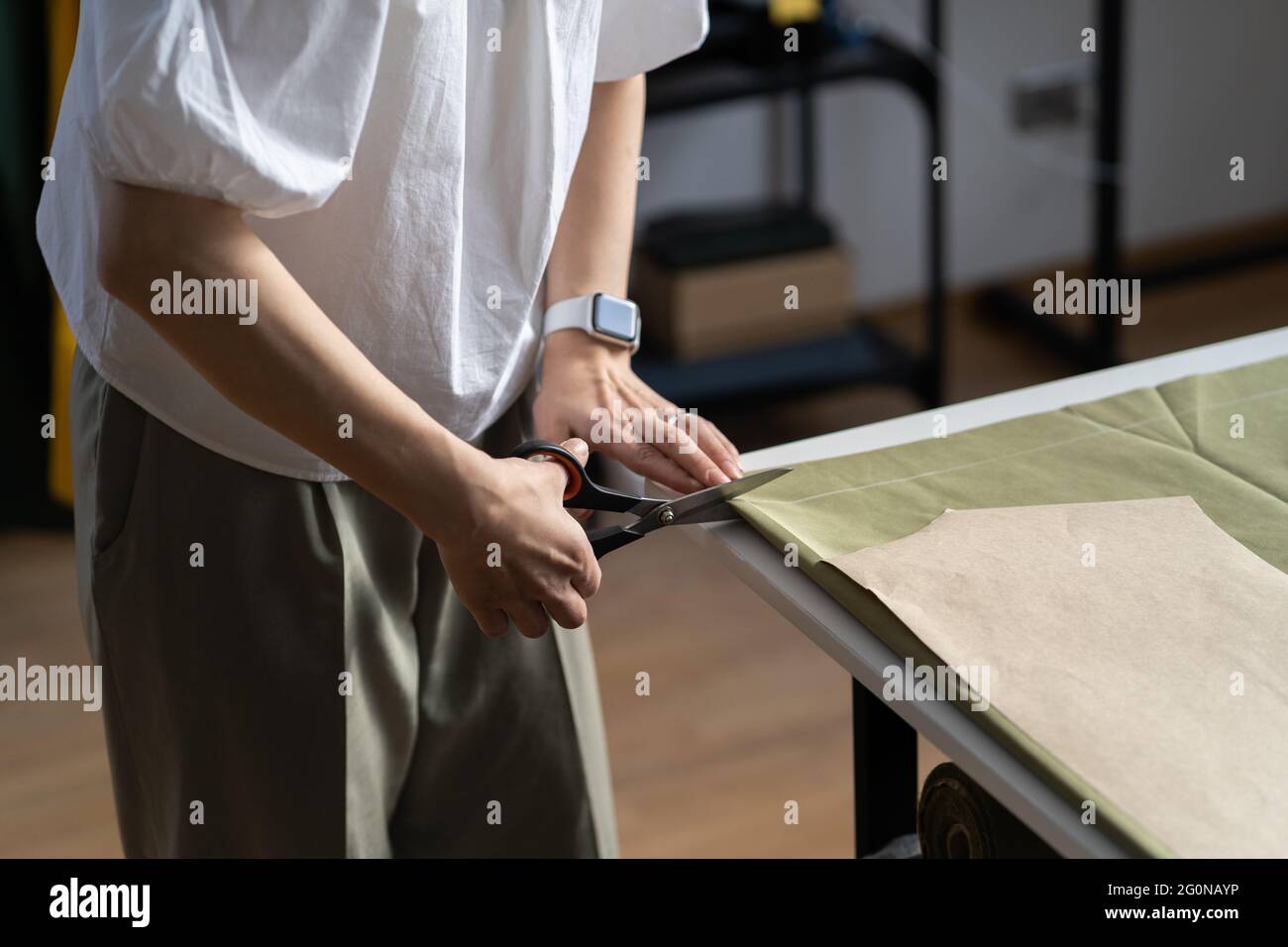 Tailor cut fabric pattern for garment. Female sewer hand hold scissors ...