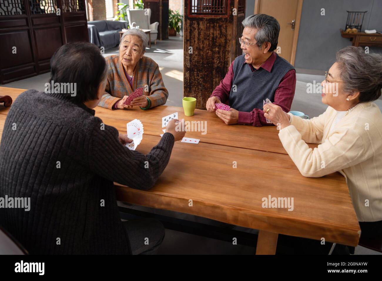 Four elderly friends playing cards hi-res stock photography and images ...