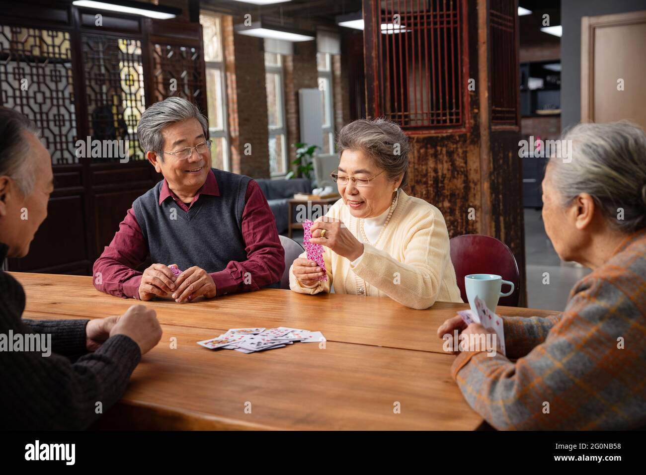 Four elderly friends playing cards hi-res stock photography and images ...