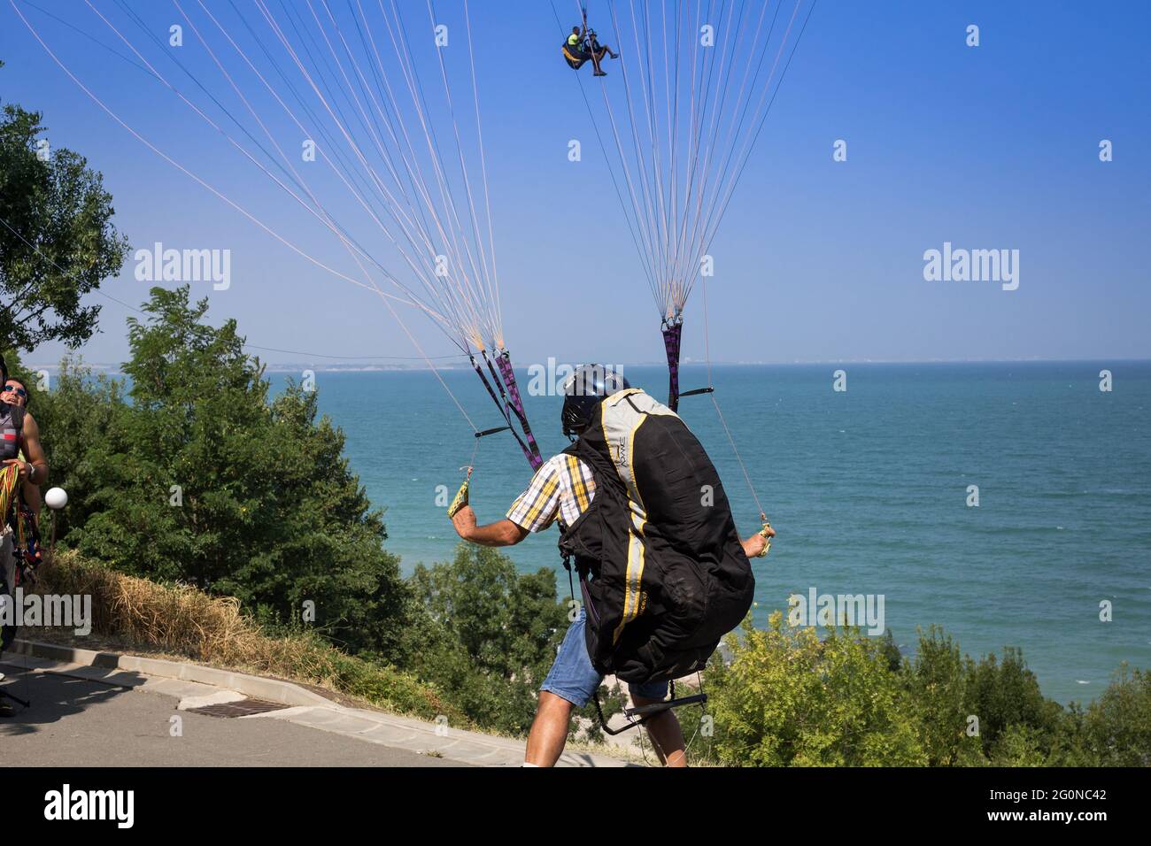 Paraglider pilot in the process of taking off on the beach Stock Photo ...