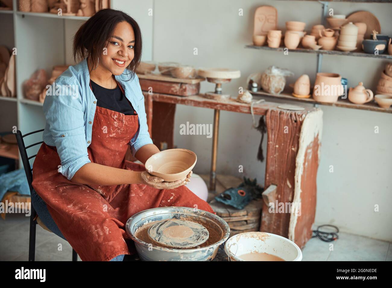 Joyful young woman ceramist working in pottery workshop Stock Photo - Alamy