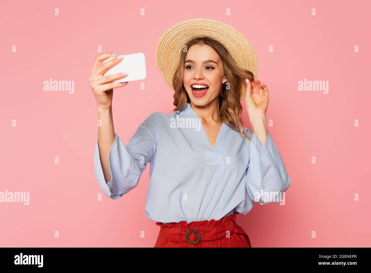 Pretty woman in summer clothes and straw hat taking selfie on ...