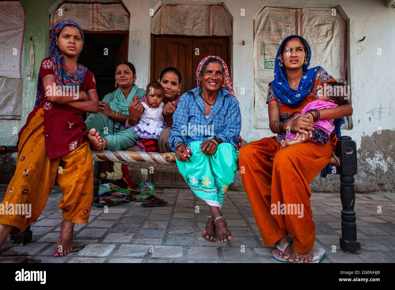 Happy Indian family with children and woman in front of a house with ...