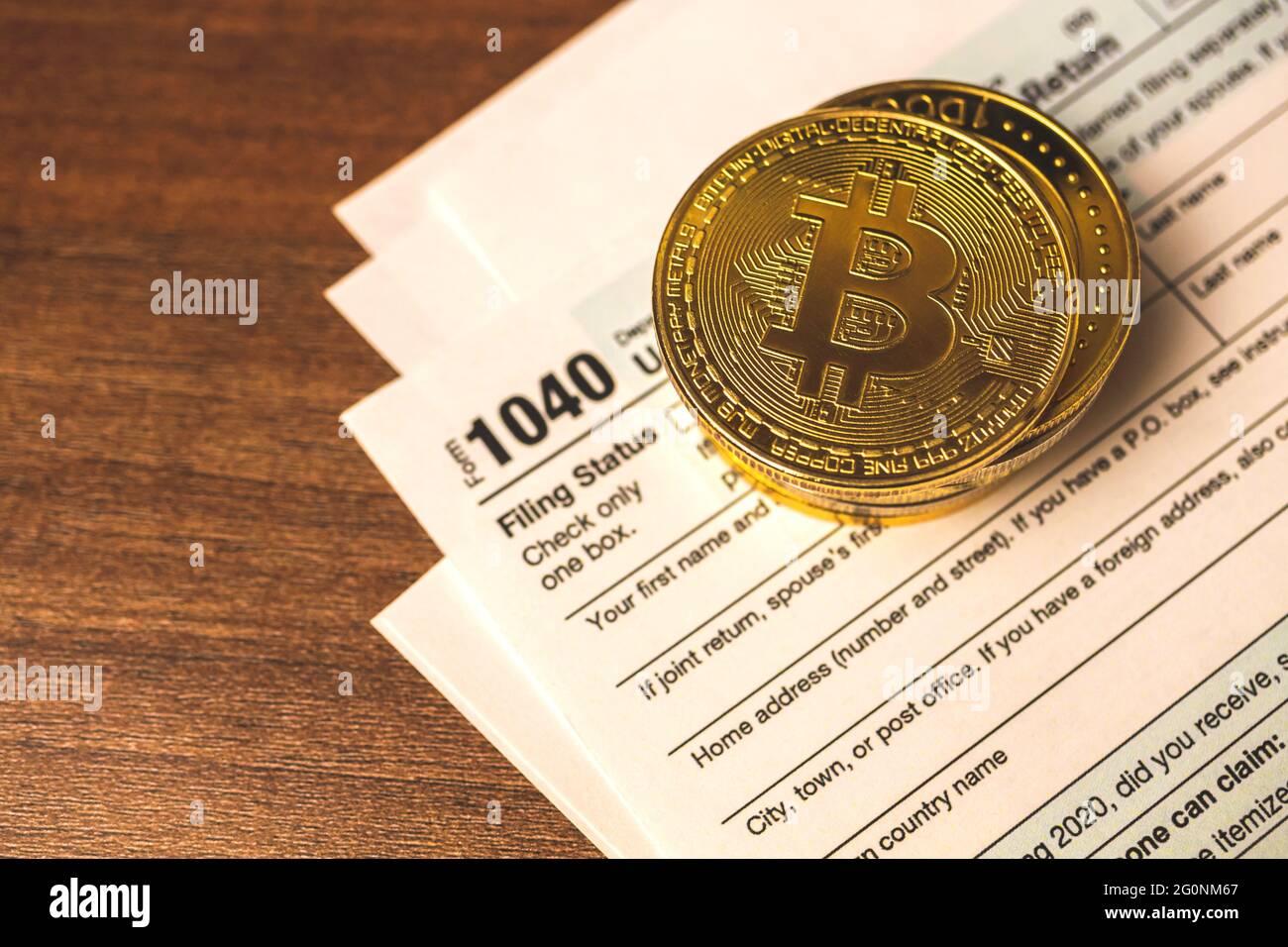 Bitcoin coin and tax form on a wooden table, top view Stock Photo - Alamy
