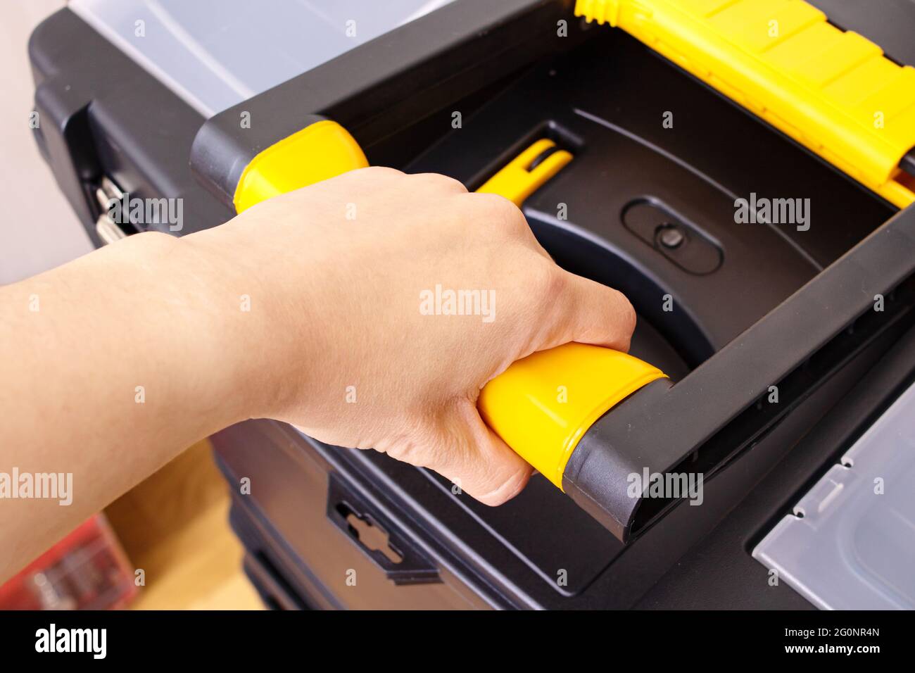 Plastic box handle with tools in hand close up Stock Photo - Alamy