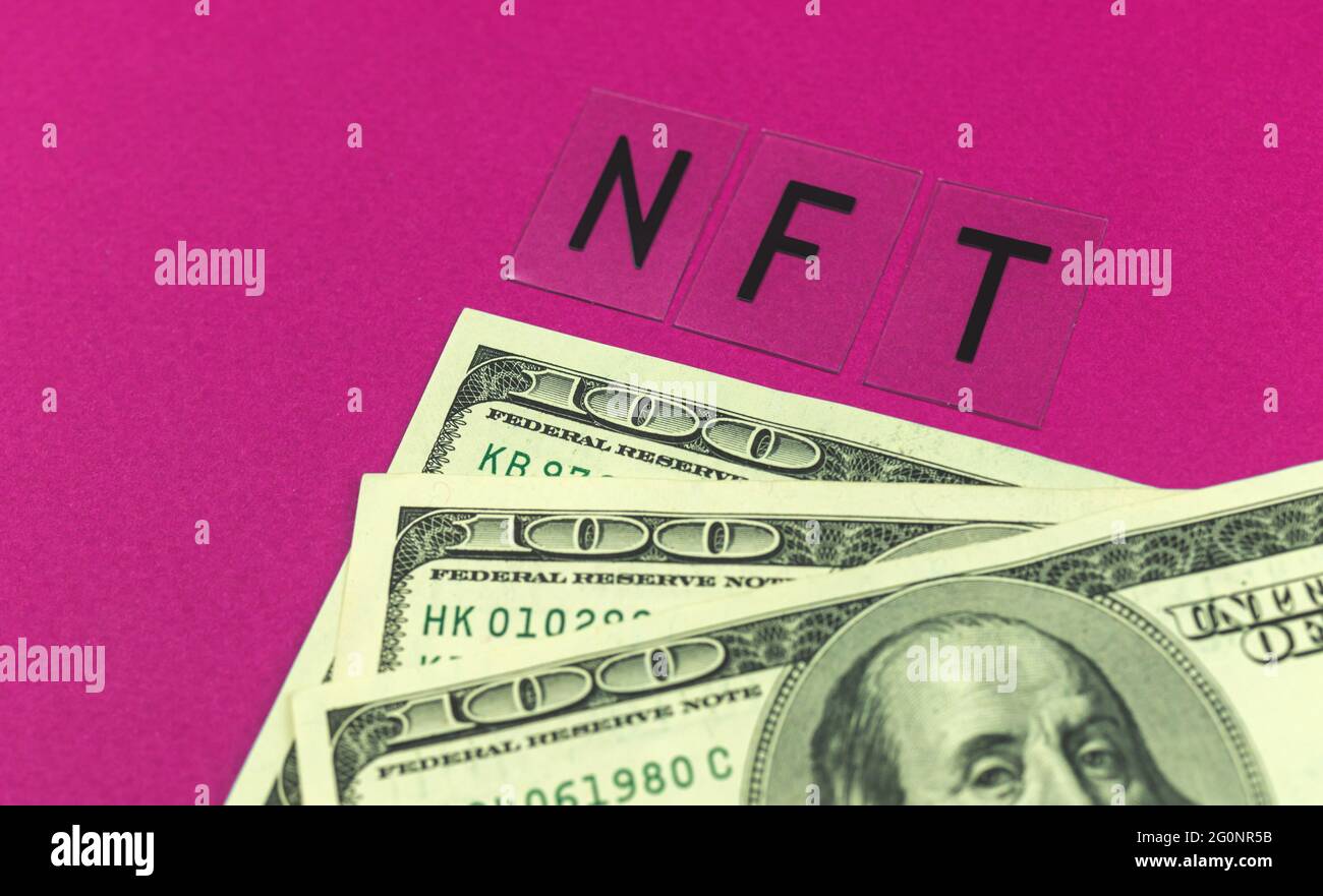 NFT and dollar bills on the office table with the purple background ...