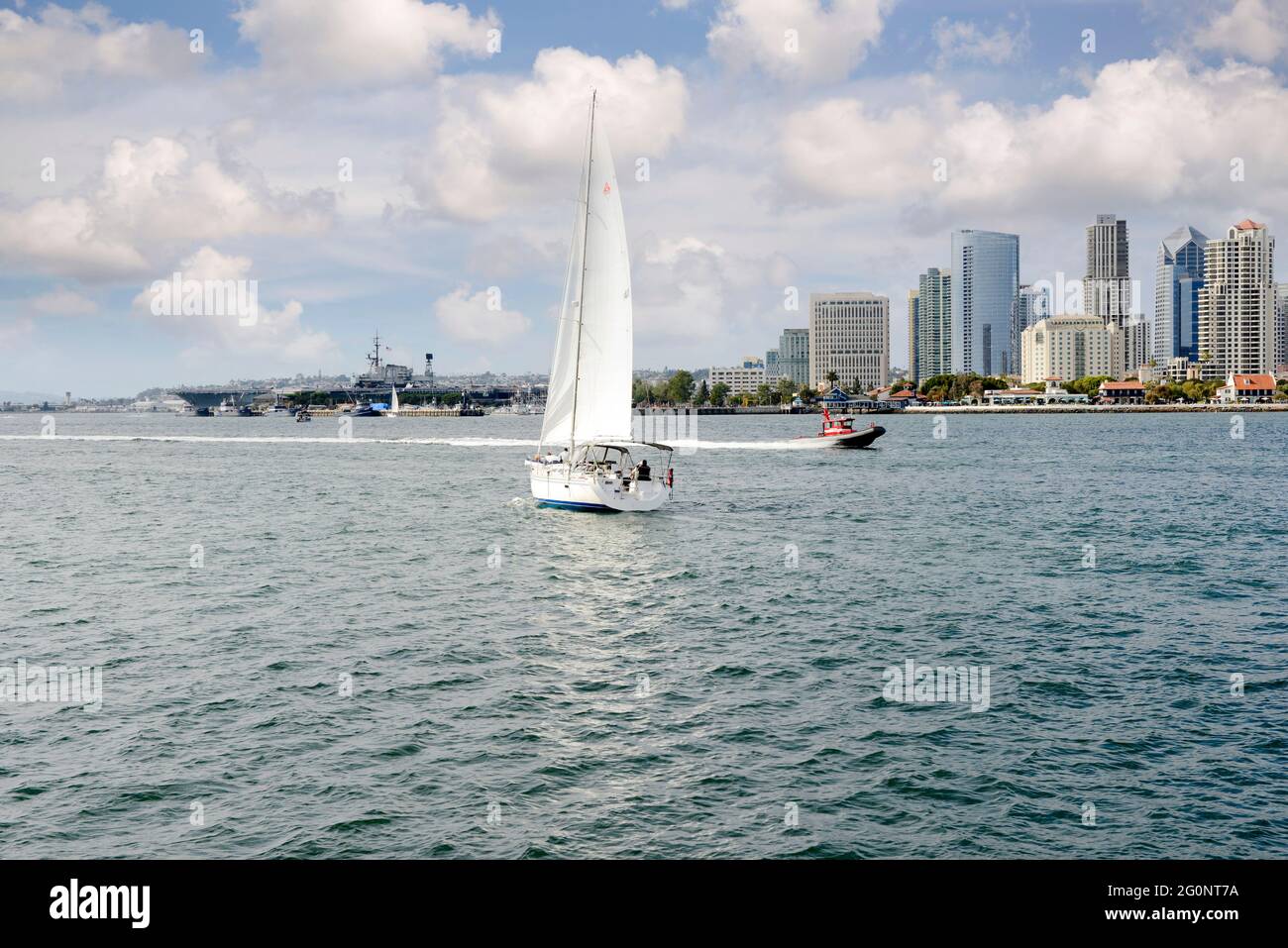 Sailboat in San Diego Bay passing the downtown skyscrapers of San Diego ...