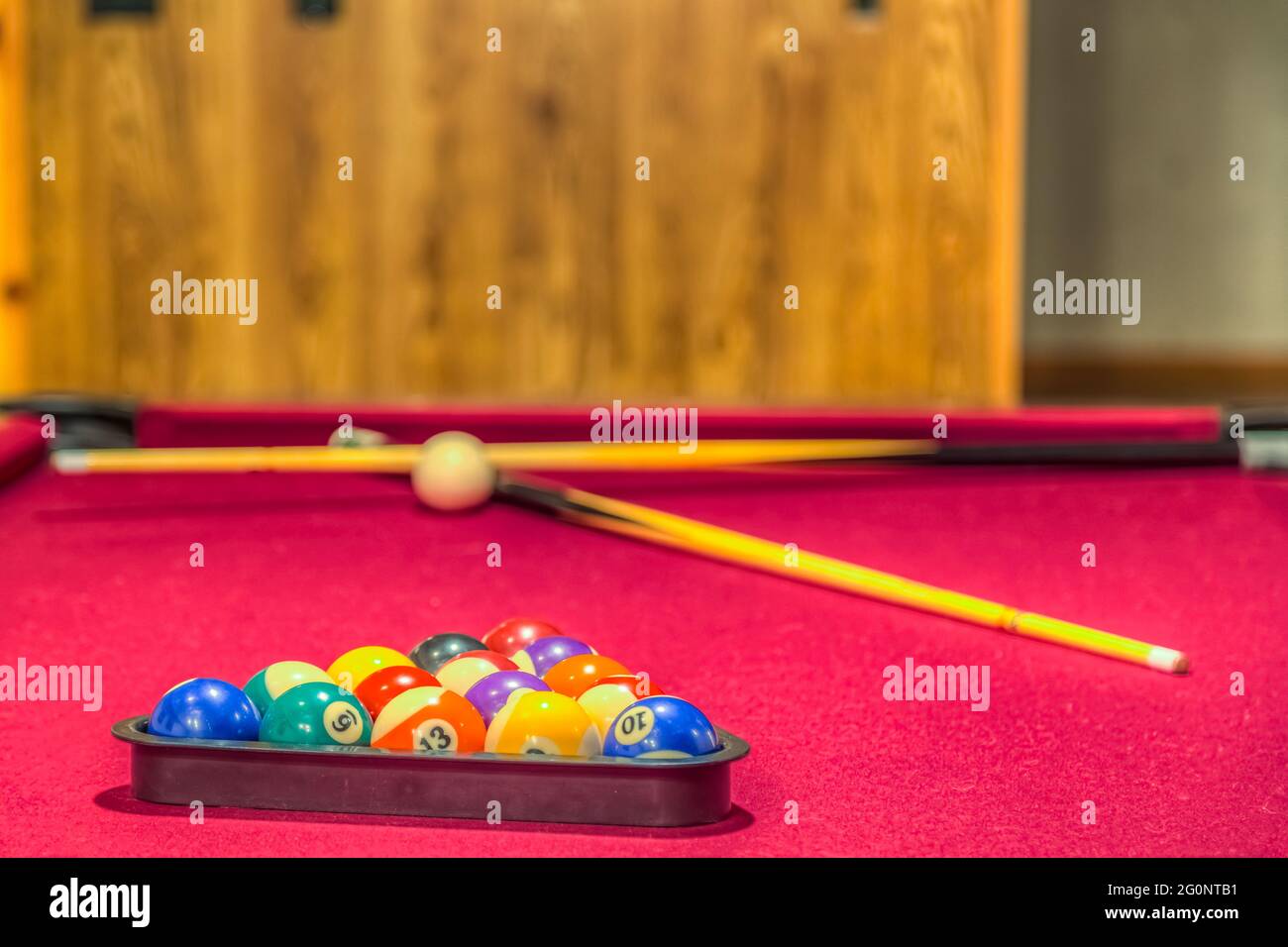 Billiard balls in a rack with cue sticks in the background Stock Photo ...