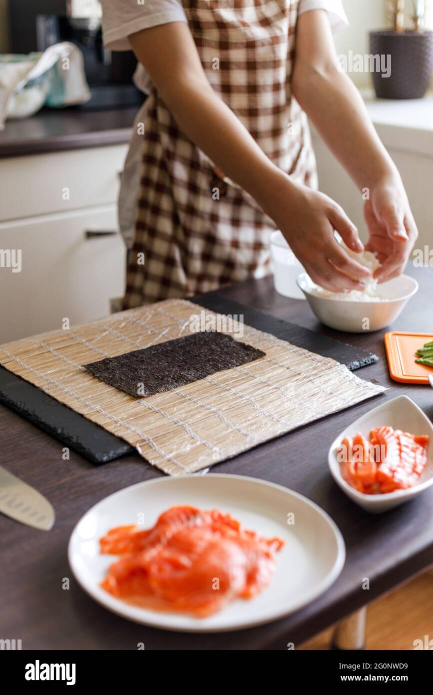 Young teenage boy making maki sushi at home Stock Photo - Alamy