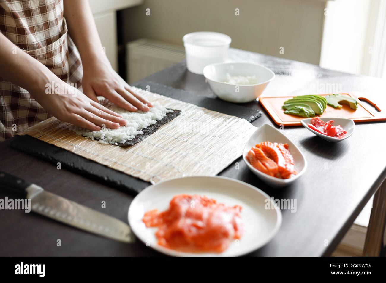 Young teenage boy making maki sushi at home Stock Photo - Alamy