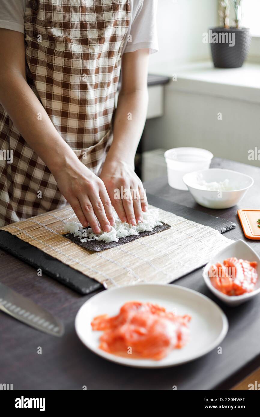Young teenage boy making maki sushi at home Stock Photo - Alamy