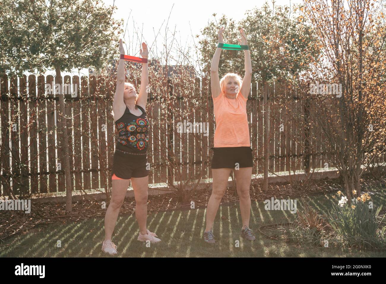 Active senior women perform hand exercises with sports rubber bands in ...