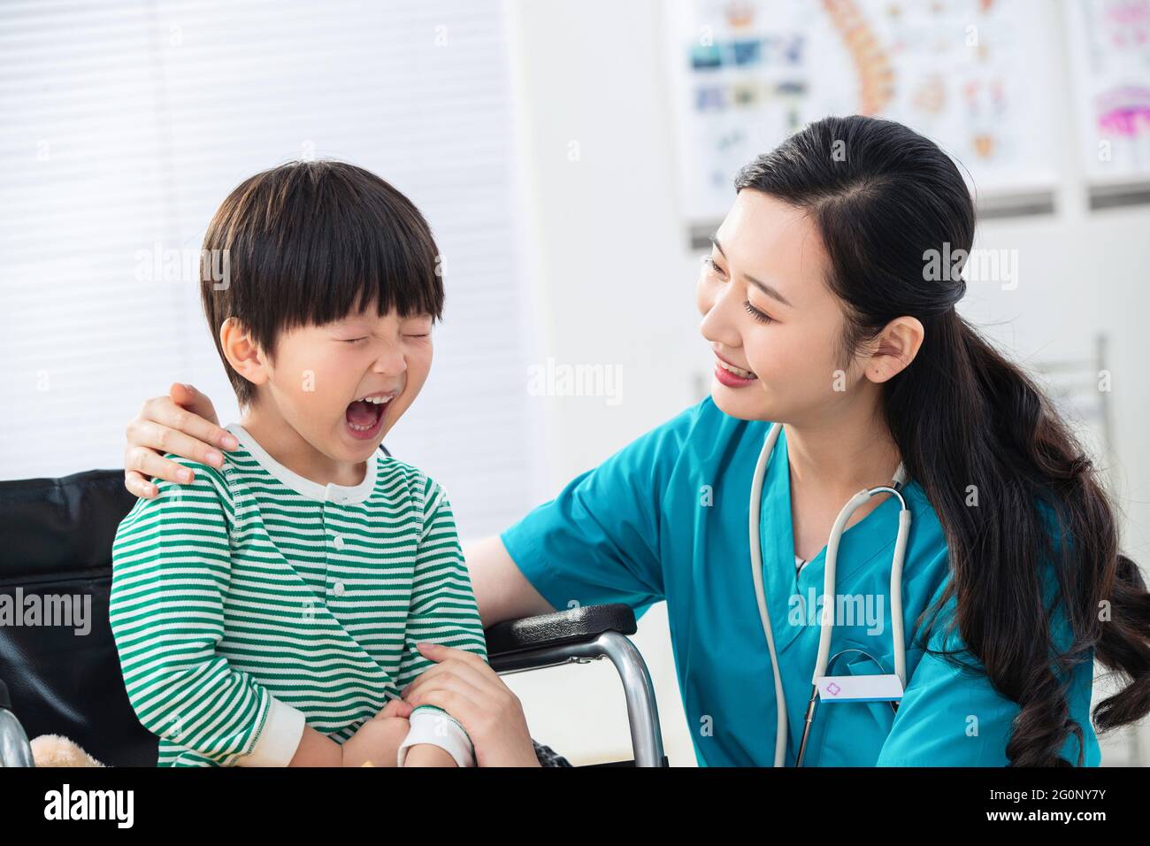 Young female doctor to comfort the crying boy Stock Photo - Alamy