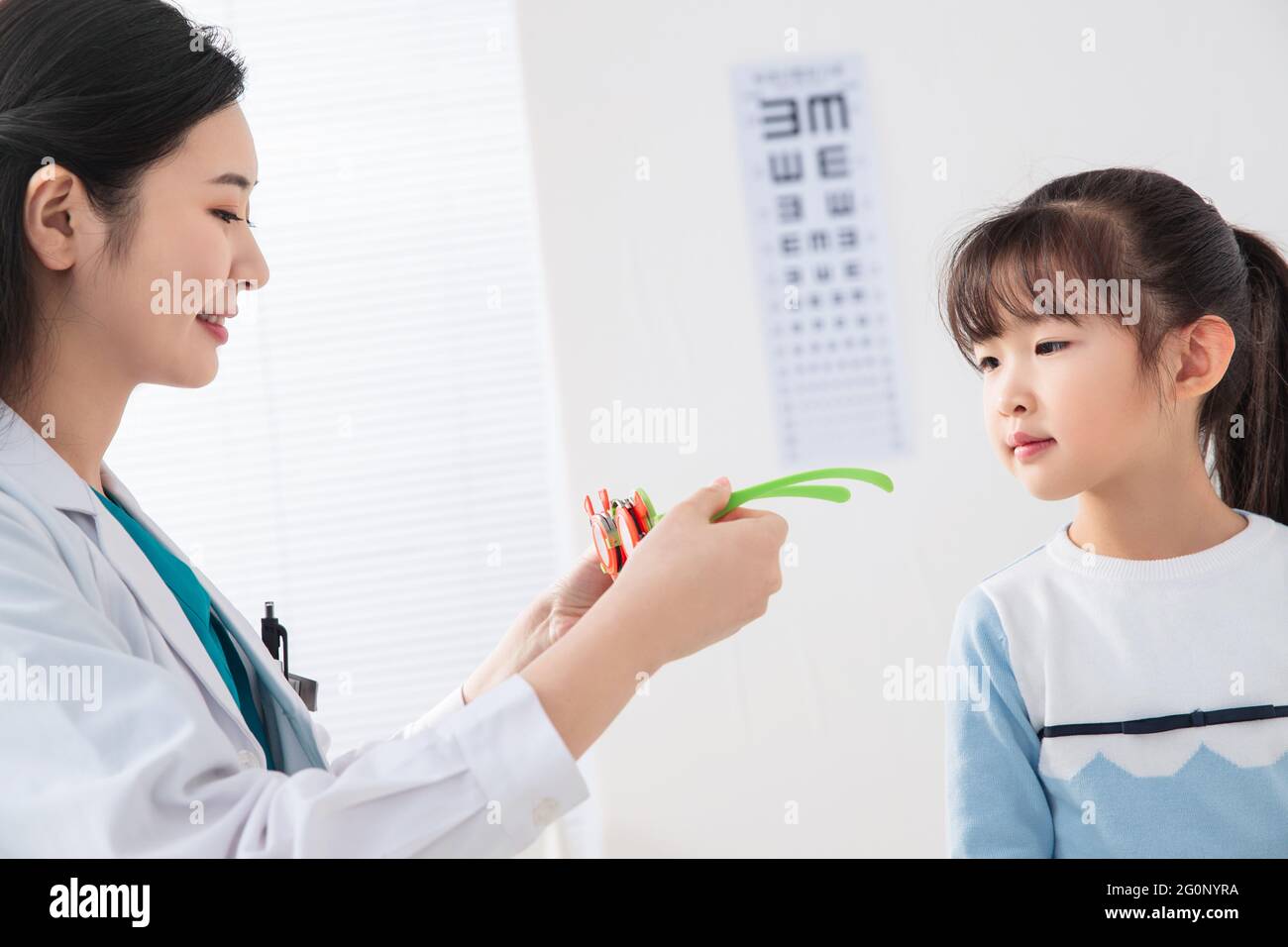 Optometrists to the little girl test visual acuity Stock Photo - Alamy