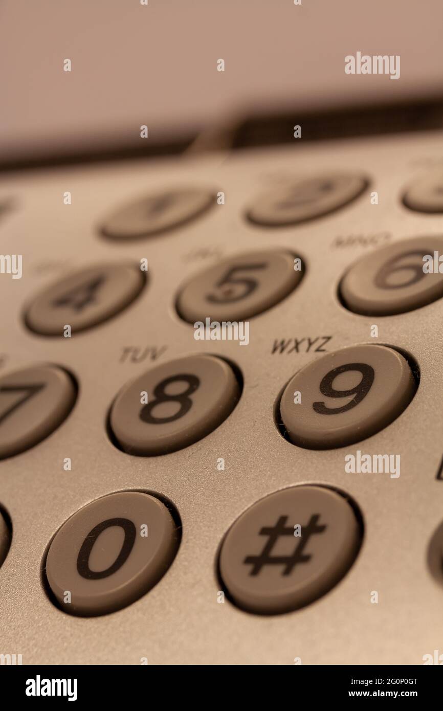 Vertical shot of the buttons of a white telephone with numbers and ...