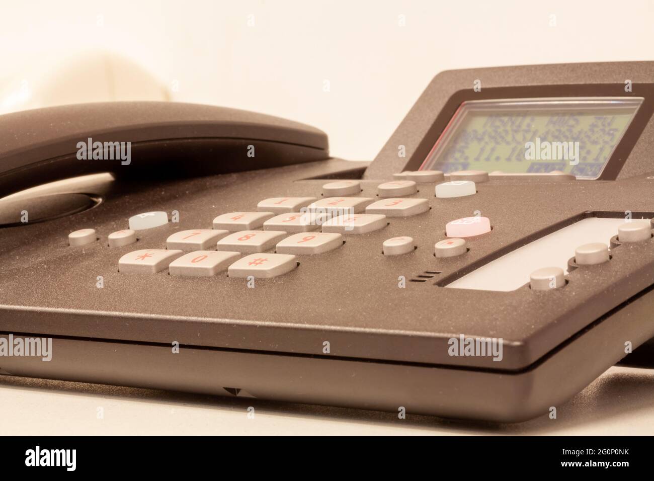 Closeup shot of a grey telephone with a screen on a white background ...