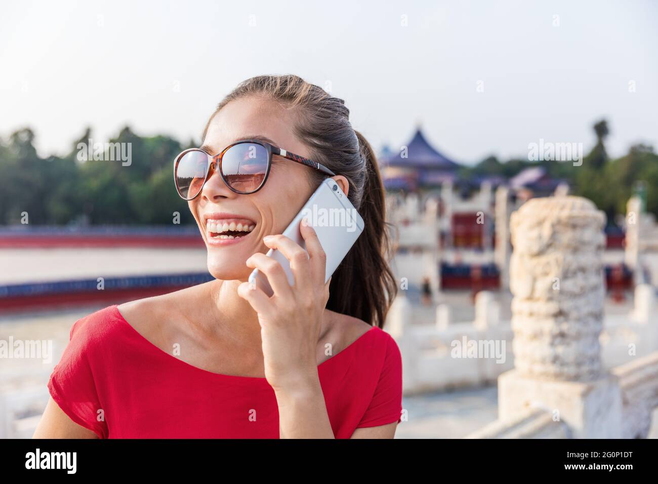 Happy asian woman talking to someone on the phone. Girl calling with ...