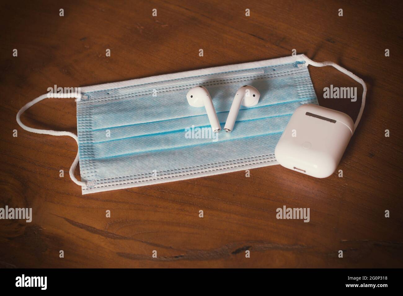 AirPods laying on a blue medical mask , concept of work from home and ...