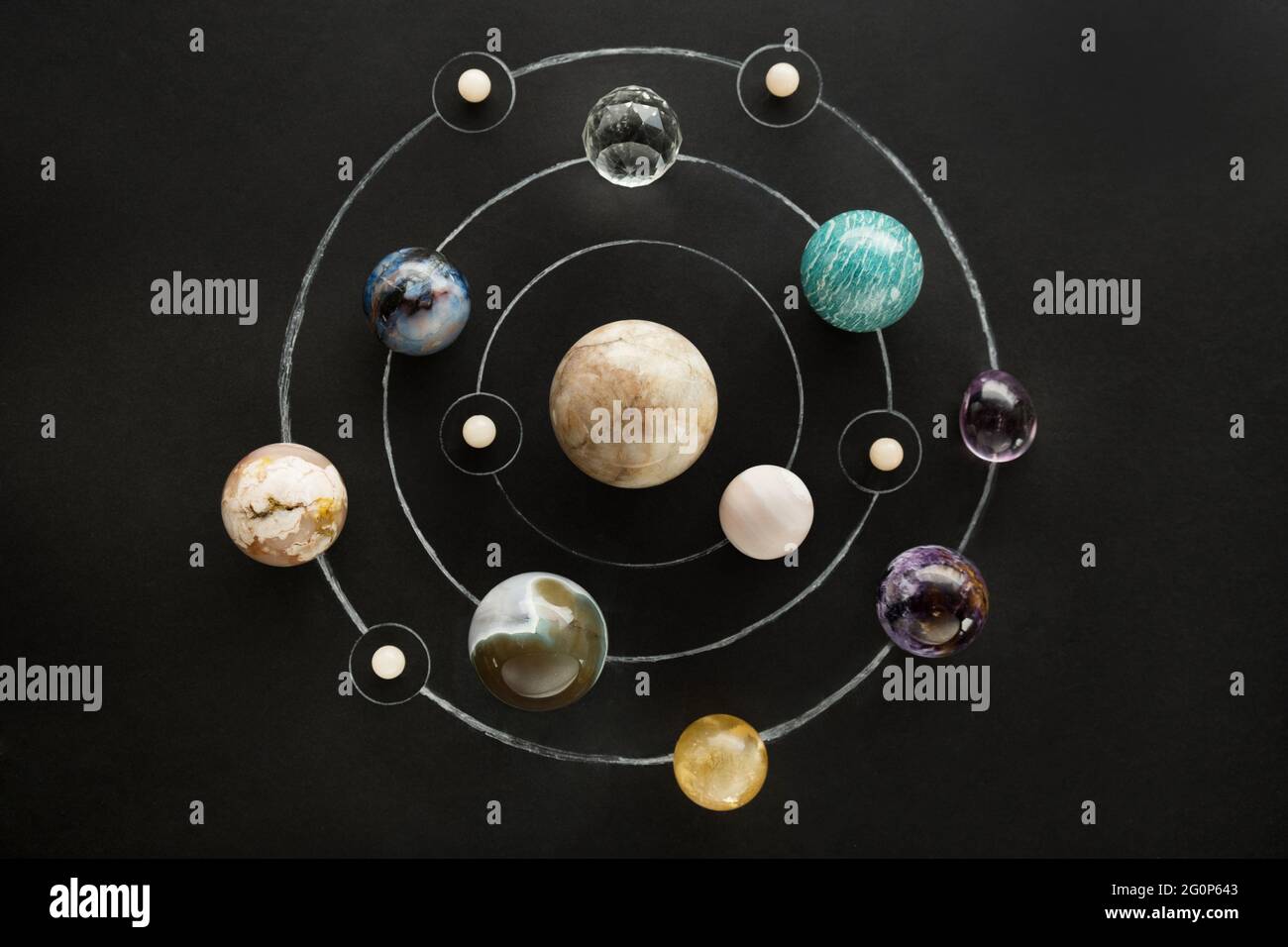 Crystal stones set in the form of a planetary system on black ...