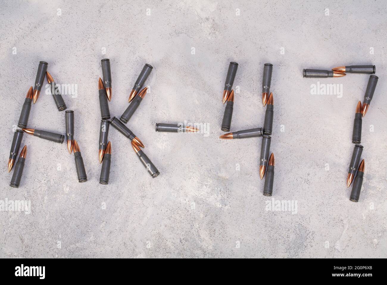 kalashnikov ak 47 word from 7,62 mm bullets on grey concrete surface ...