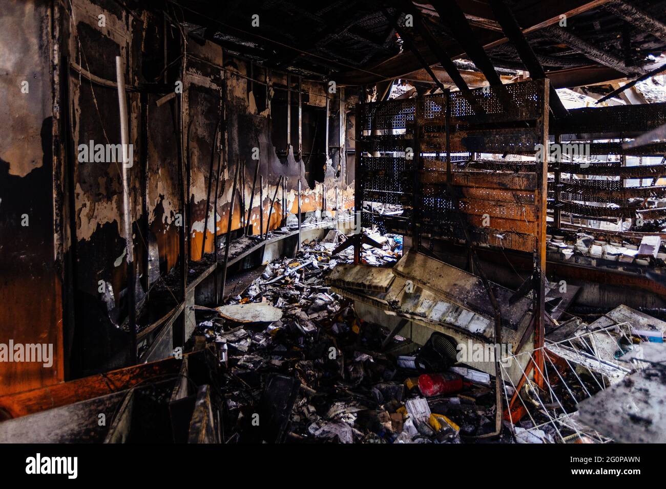 Burnt out shop after fire with charred walls and remains of furniture ...