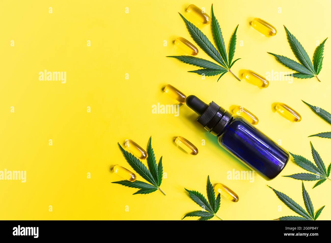 CBD Cannabidiol bottle Capsules and Cannabis leafs on yellow background ...