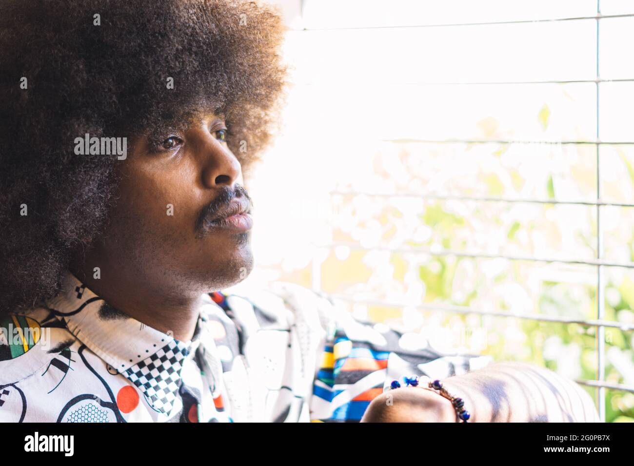 closeup of young black guy with afro hair and mustache in profile next ...