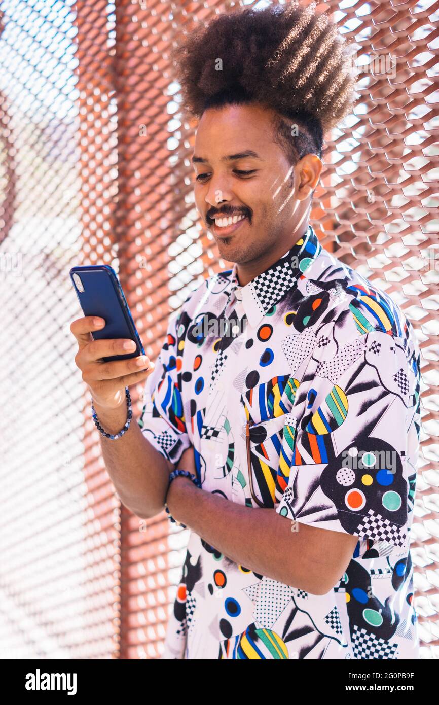 vertical image of black guy with afro hair pulled back looking at his ...