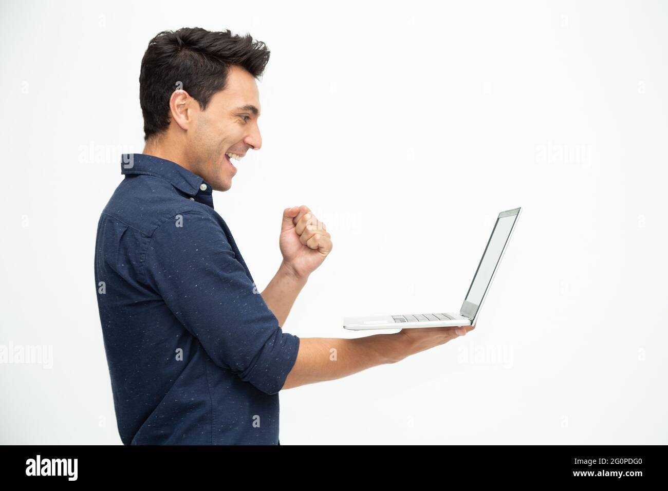 Portrait of an excited man holding laptop computer and celebrating ...