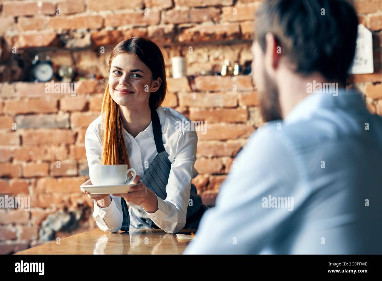female waiter with a cup of coffee serving customer cafe Stock Photo ...