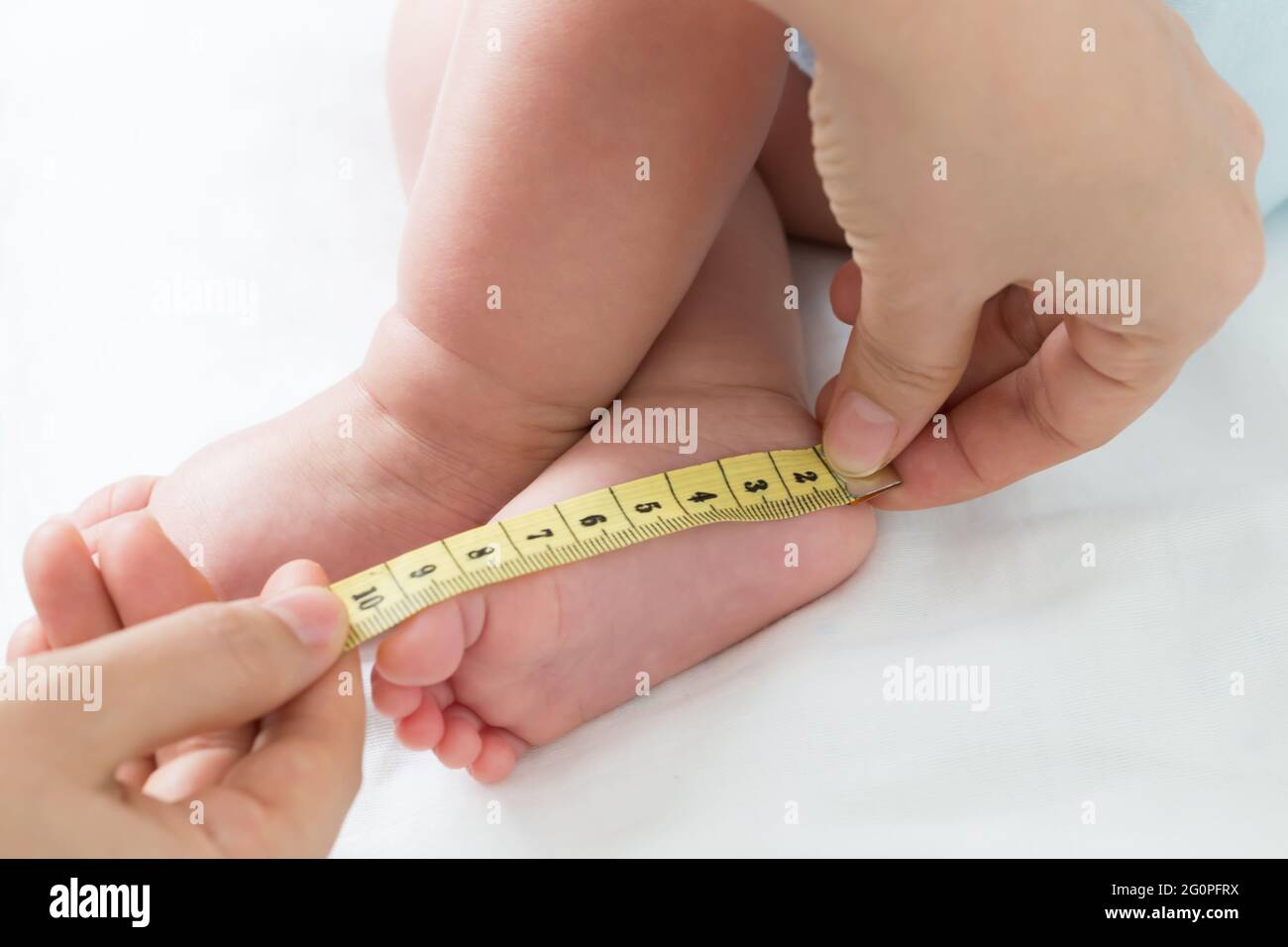 Measuring the size of the foot baby Stock Photo - Alamy