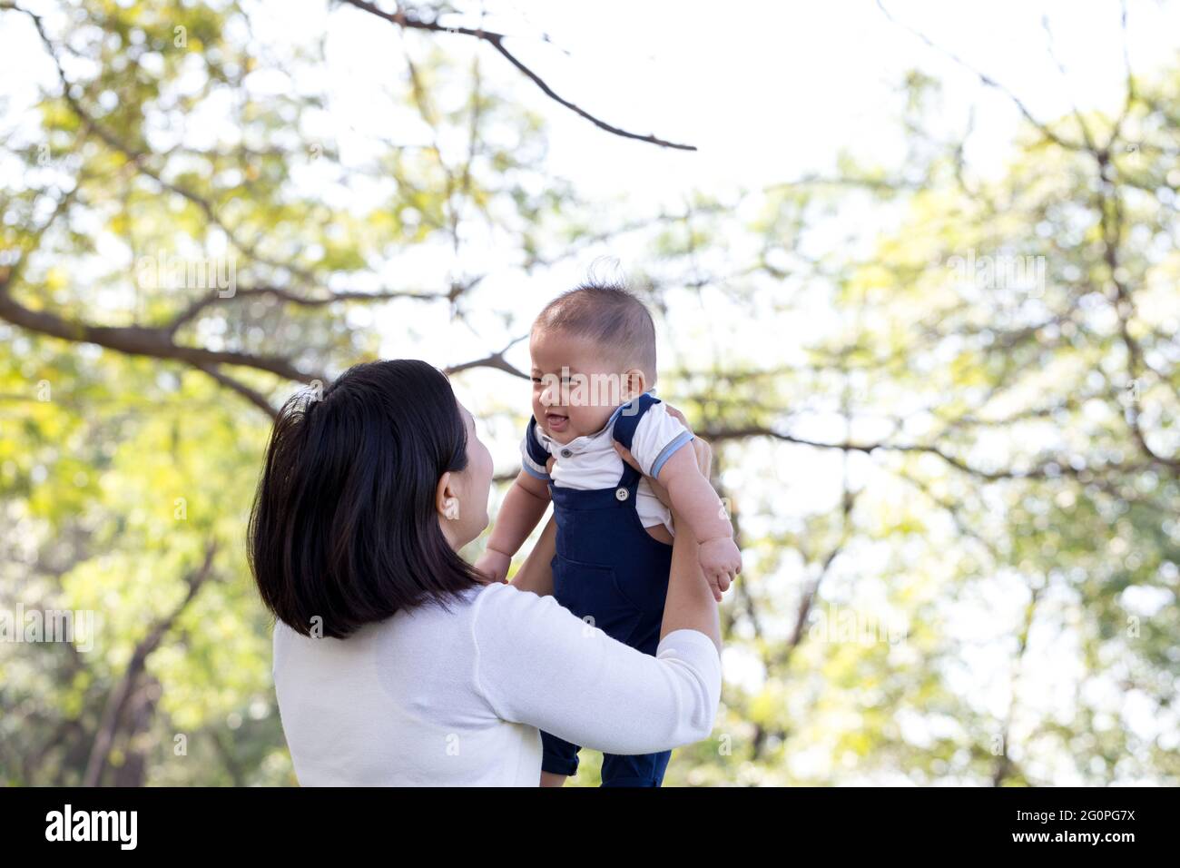 Happy young mother playing and having fun with little baby son in the ...