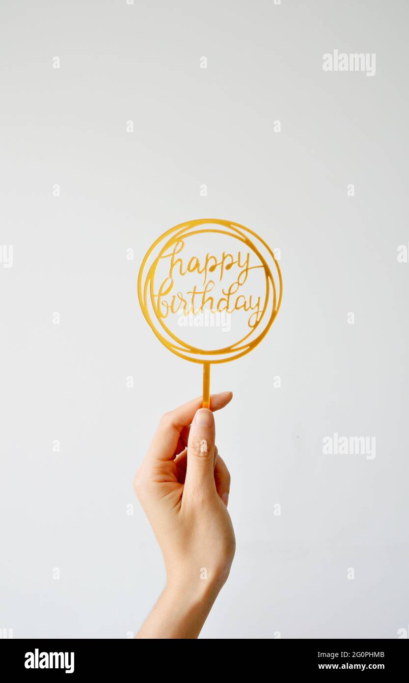 Cropped hand holding round golden acrylic Happy Birthday Party Sign in ...
