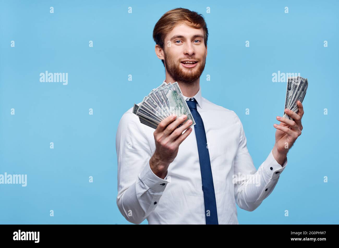 rich man in suit with money in hands emotions blue background Stock ...